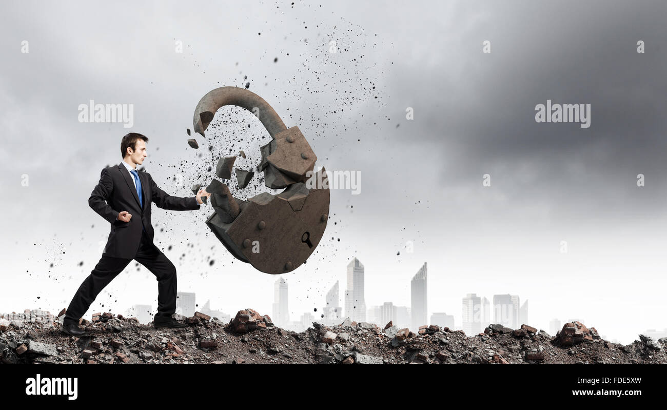 Businessman breaking stone lock with karate kick Stock Photo - Alamy