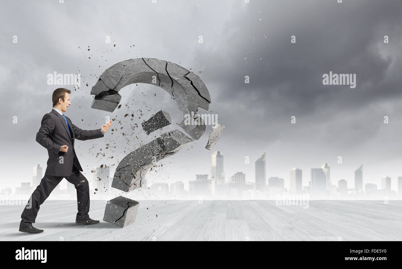 Businessman breaking stone question mark with karate kick Stock Photo ...