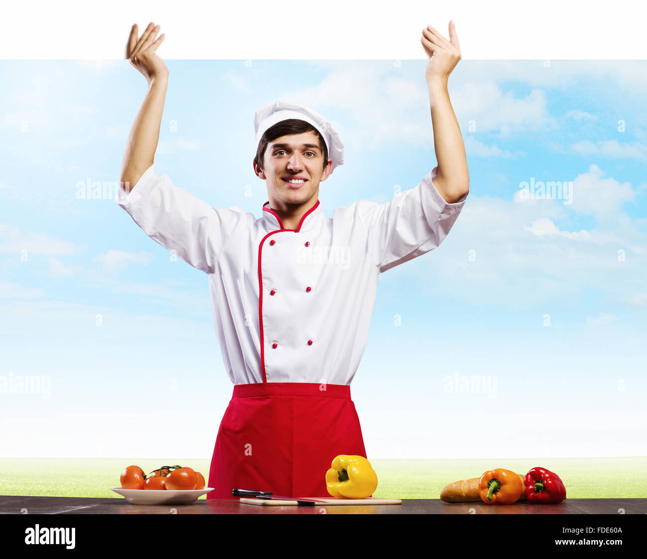 Young handsome cook holding white blank banner Stock Photo - Alamy