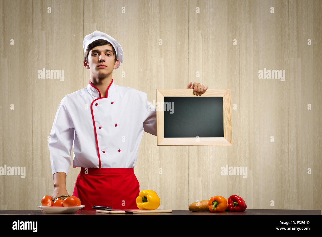Handsome cook holding blank chalk board. Place for text Stock Photo - Alamy