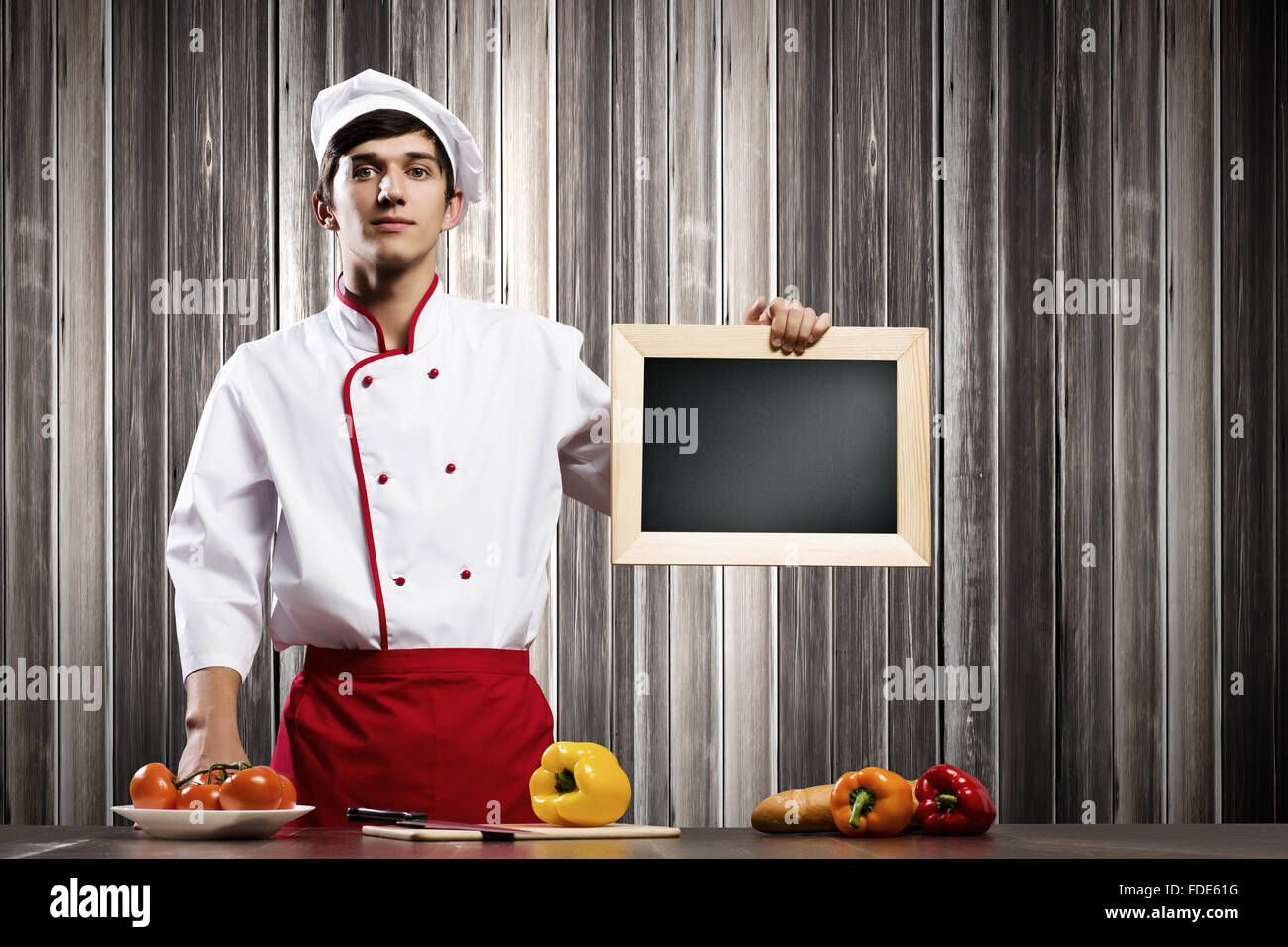 Handsome cook holding blank chalk board. Place for text Stock Photo - Alamy
