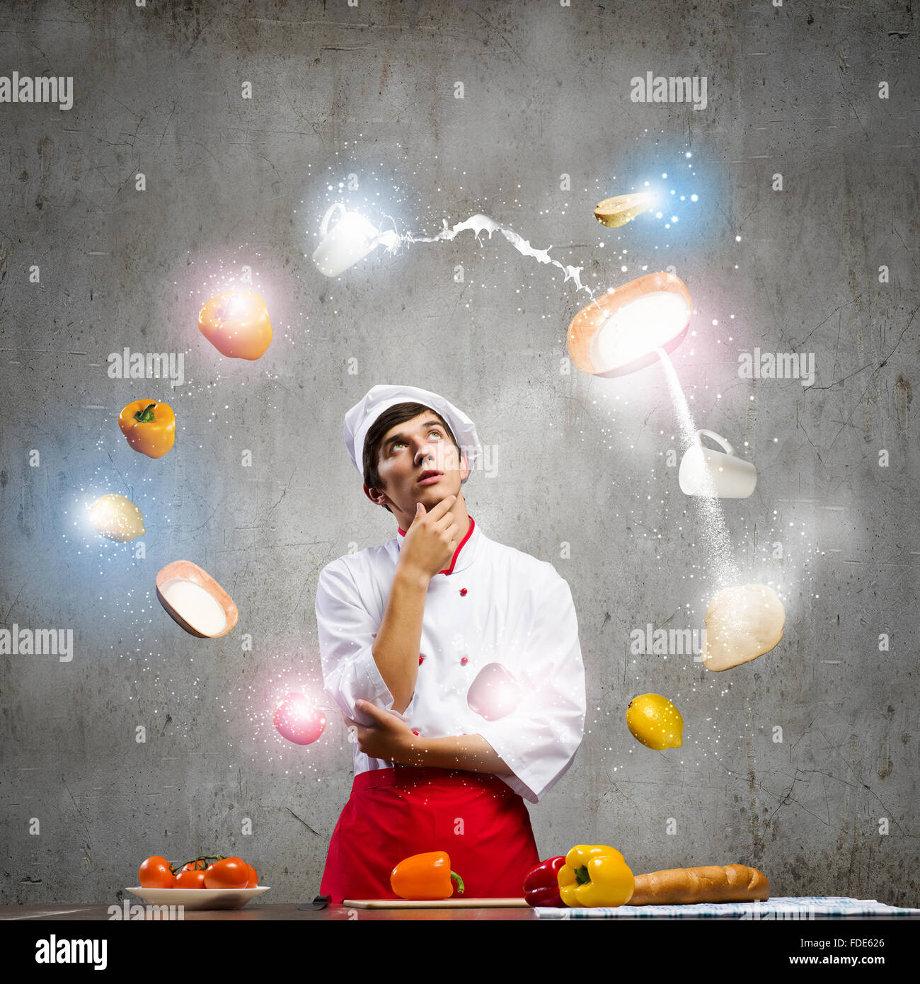 Young thoughtful cook and ingredients flying in air Stock Photo - Alamy