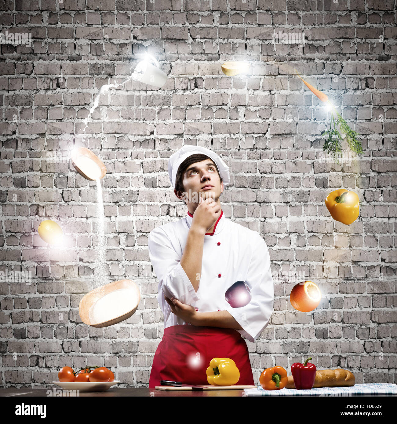 Young thoughtful cook and ingredients flying in air Stock Photo - Alamy