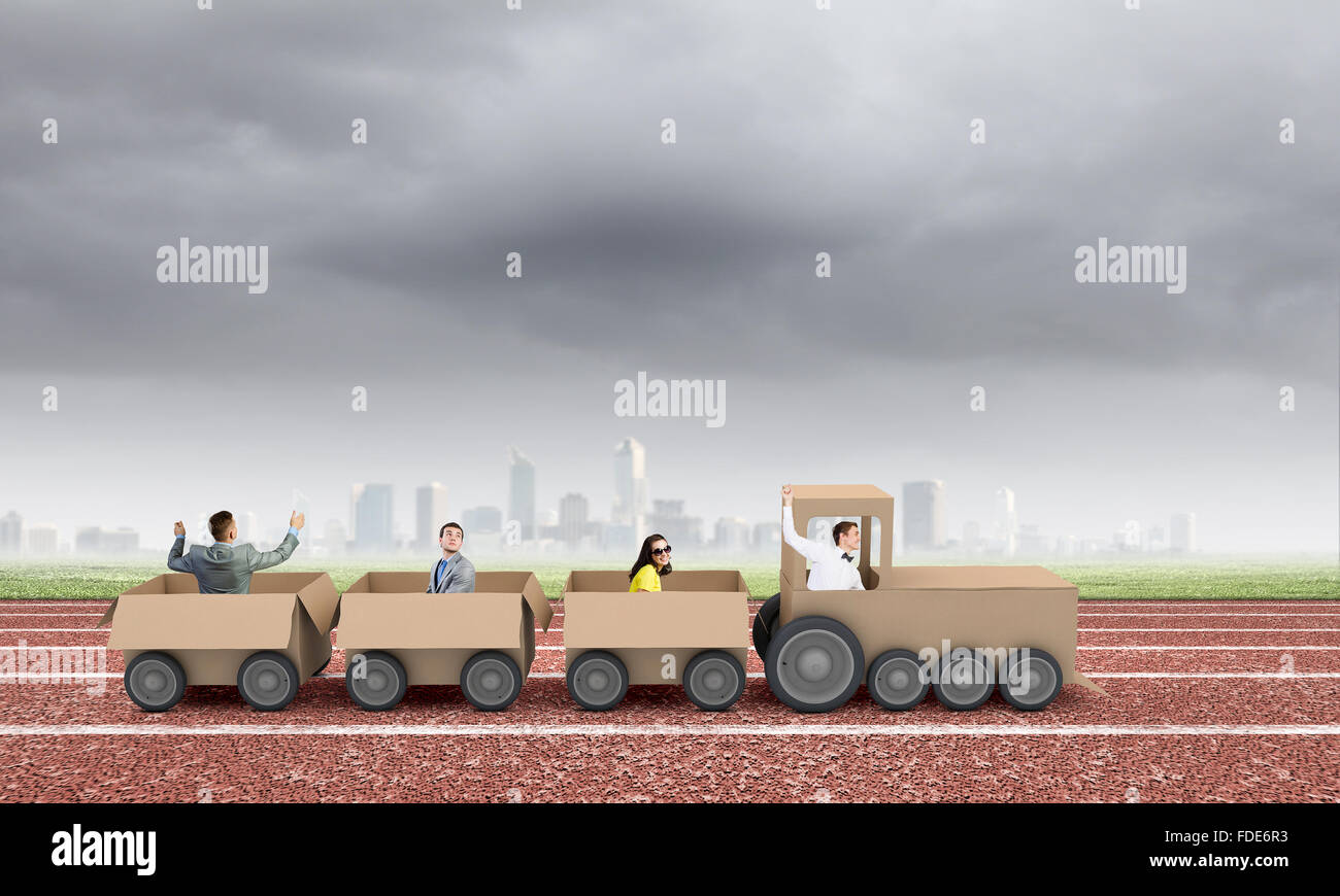 Young business people riding carton train. Teamwork concept Stock Photo ...