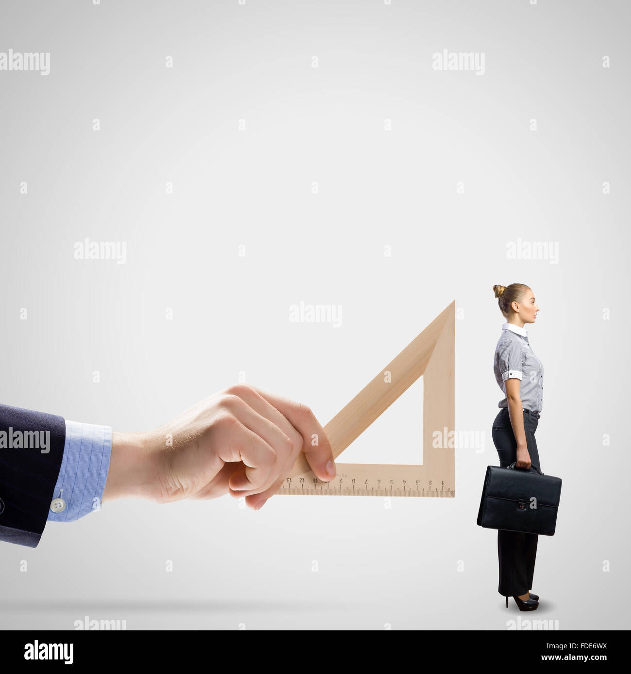 Businessman measuring miniature of business lady with ruler Stock Photo ...