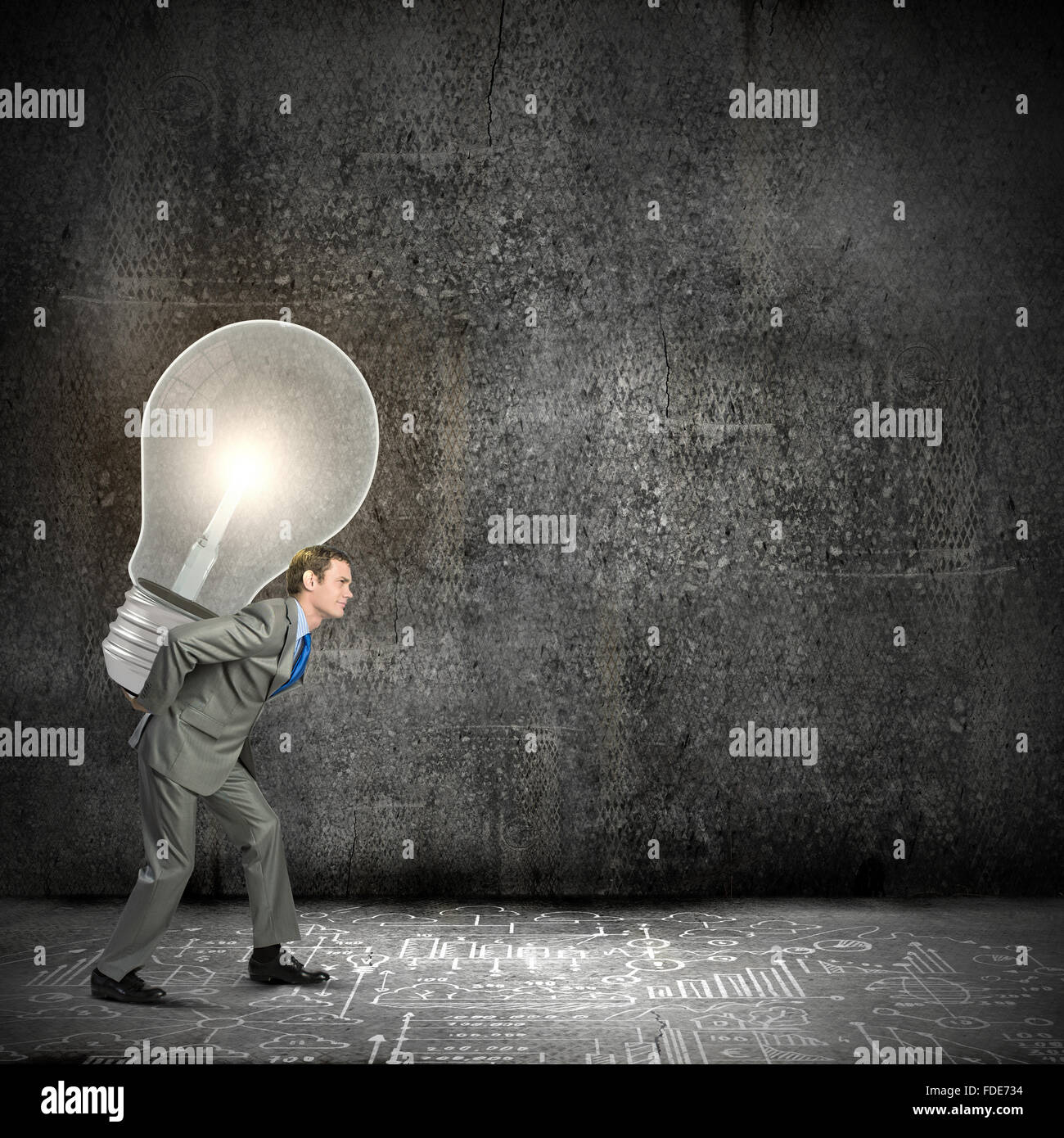 Young businessman carrying big light bulb on back Stock Photo - Alamy
