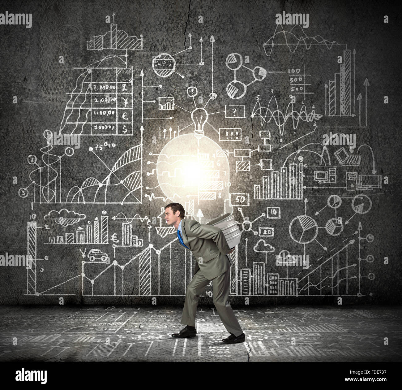 Young businessman carrying big light bulb on back Stock Photo - Alamy
