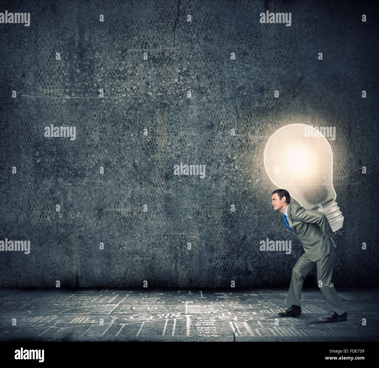 Young businessman carrying big light bulb on back Stock Photo - Alamy