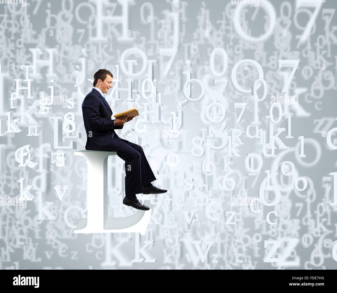 Young businessman sitting on letter and reading book Stock Photo - Alamy