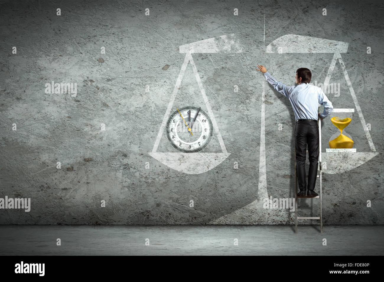 Businessman on ladder pointing at scale picture Stock Photo - Alamy