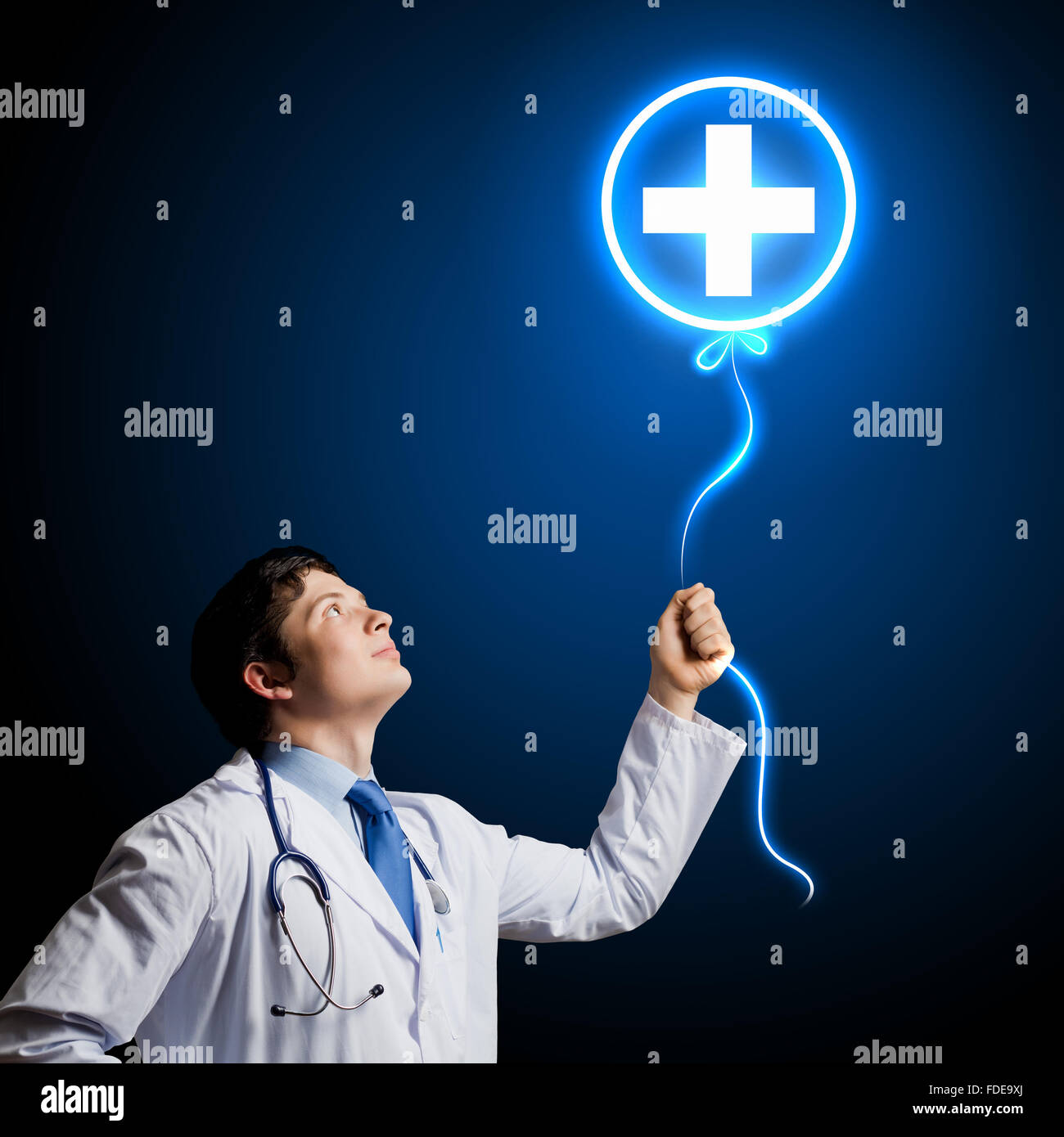 Young male doctor holding balloon with medical sign Stock Photo - Alamy