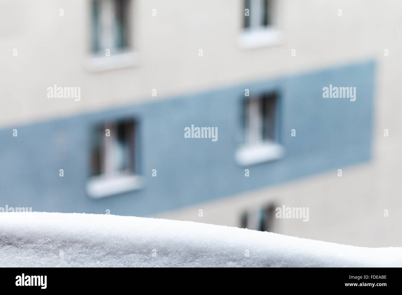 snow on windowsill and apartment house on background in cold winter day ...
