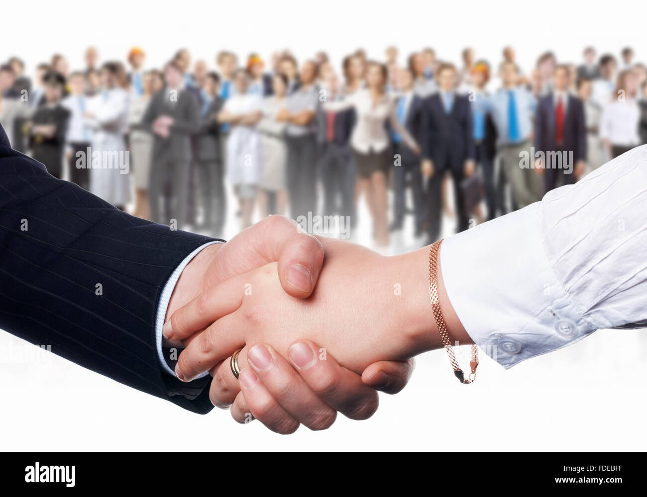 Close-up of human handshake with crowd of people at background Stock ...