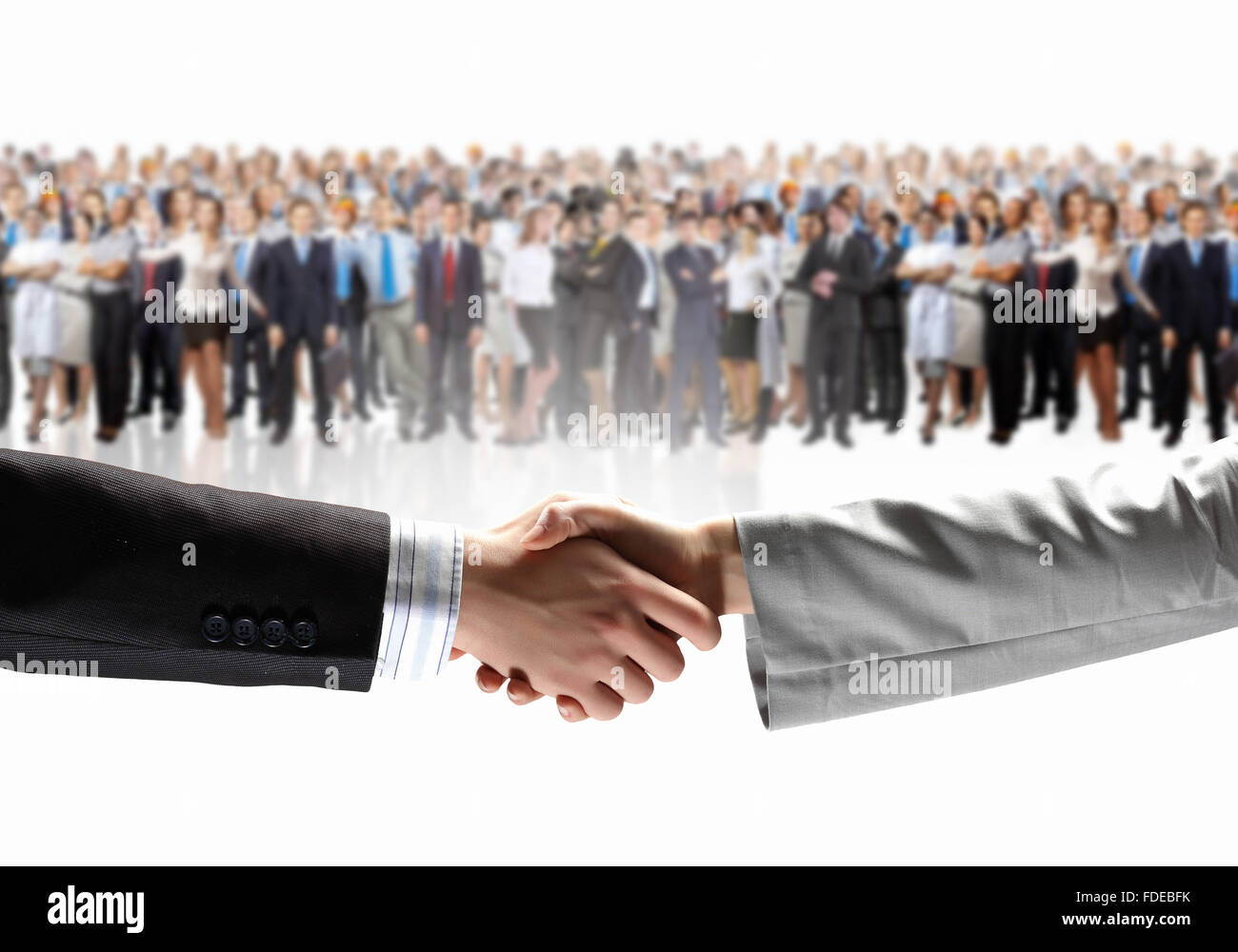 Close-up of human handshake with crowd of people at background Stock ...