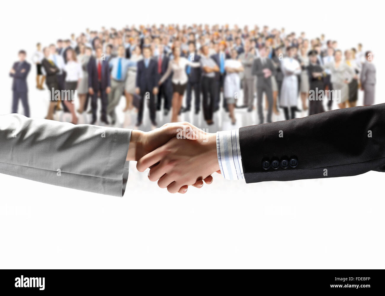 Close-up of human handshake with crowd of people at background Stock ...