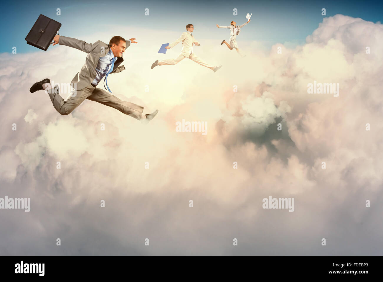 Image of businesspeople jumping high in sky Stock Photo - Alamy