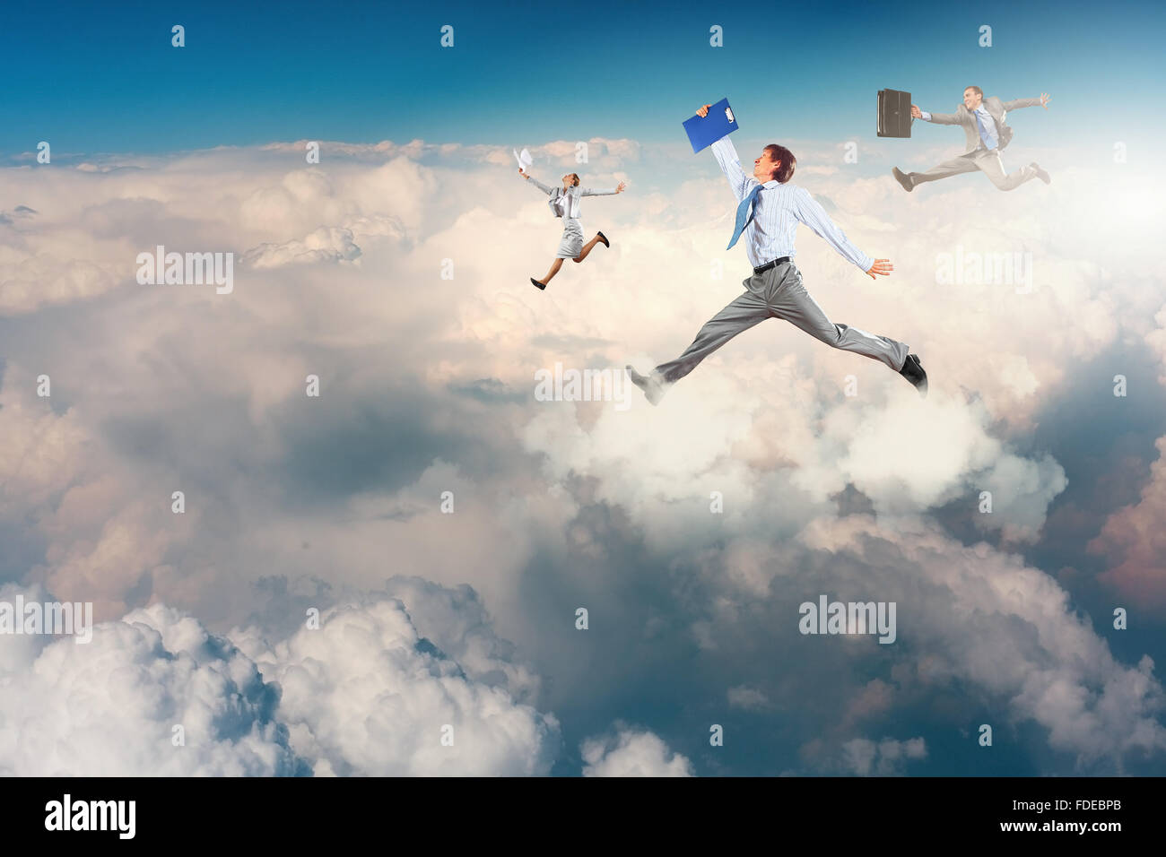 Image of businesspeople jumping high in sky Stock Photo - Alamy