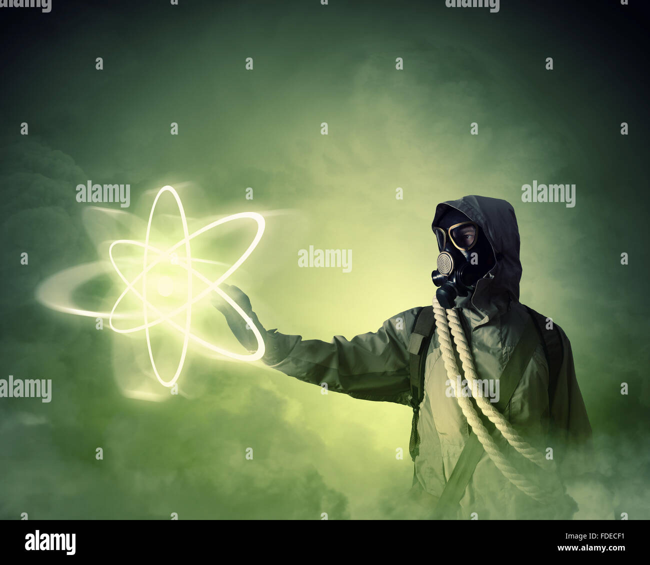 Image of man in gas mask and protective uniform touching atom sign ...