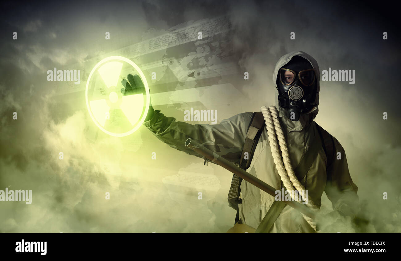 Image of man in gas mask and protective uniform touching radioactivity ...