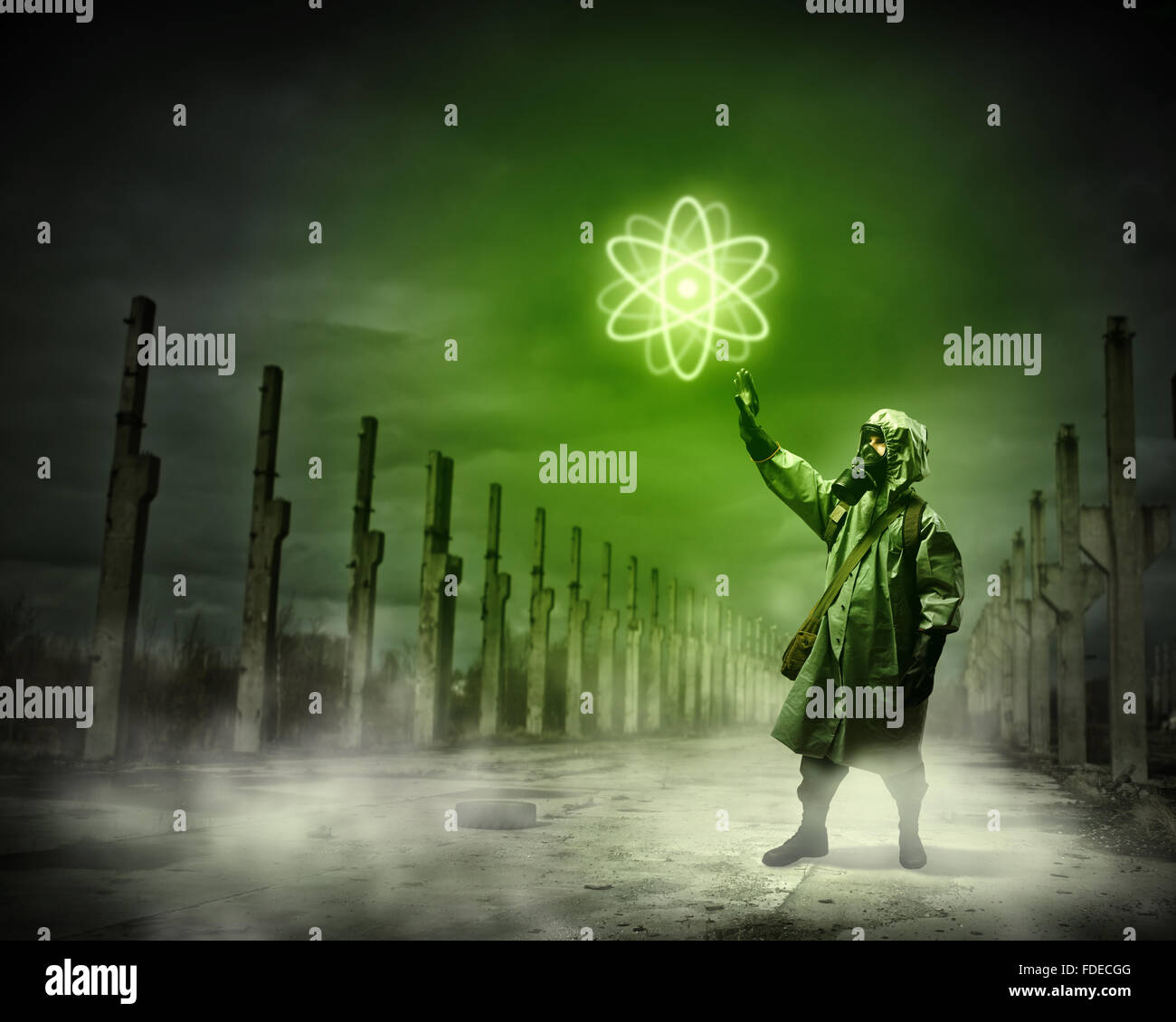 Image of man in gas mask and protective uniform touching atom sign ...