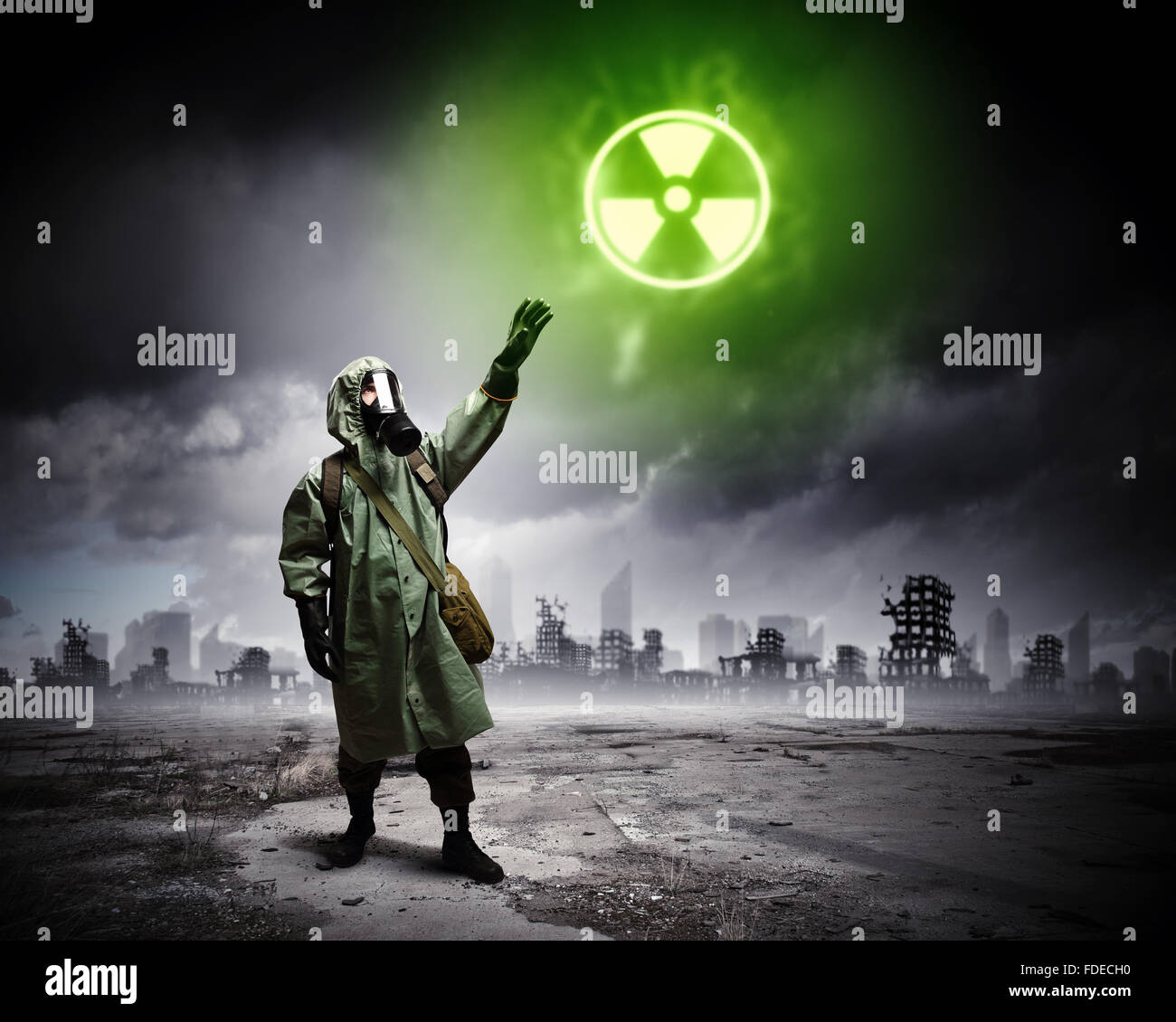 Image of man in gas mask and protective uniform touching radioactivity ...