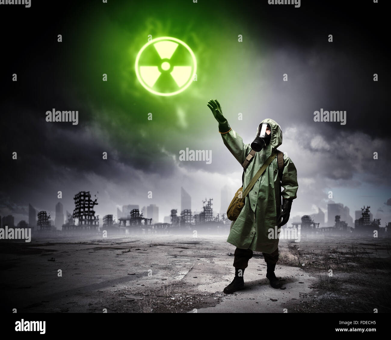 Image of man in gas mask and protective uniform touching radioactivity ...