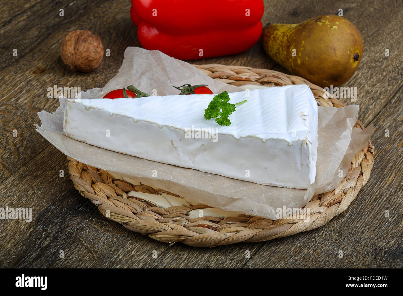 Brie cheese triangle with tomato and parsley Stock Photo - Alamy