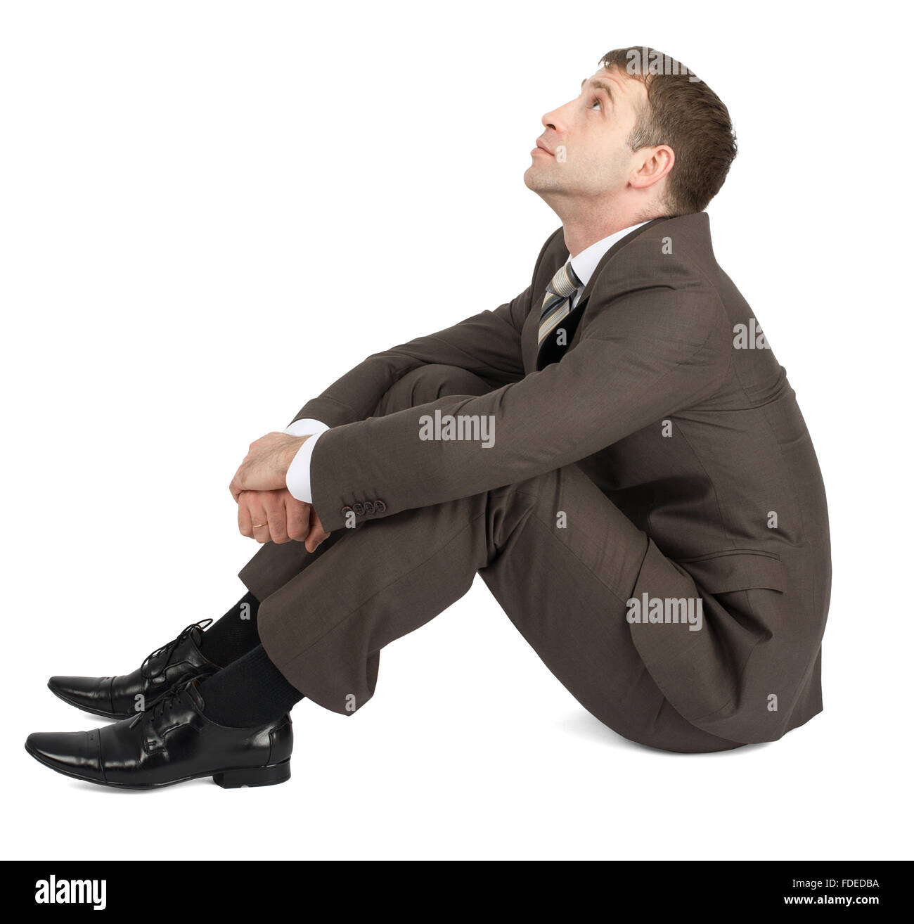 Businessman sitting and looking up Stock Photo - Alamy