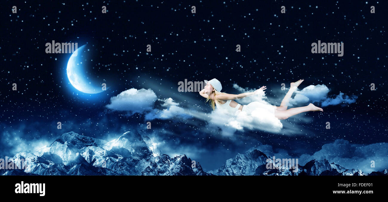 Young blond girl flying in night sky Stock Photo - Alamy
