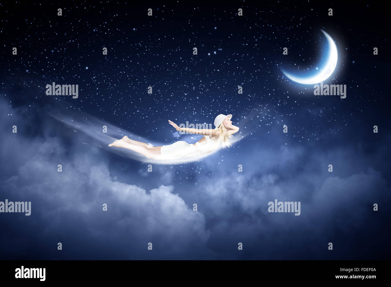 Young blond girl flying in night sky Stock Photo - Alamy