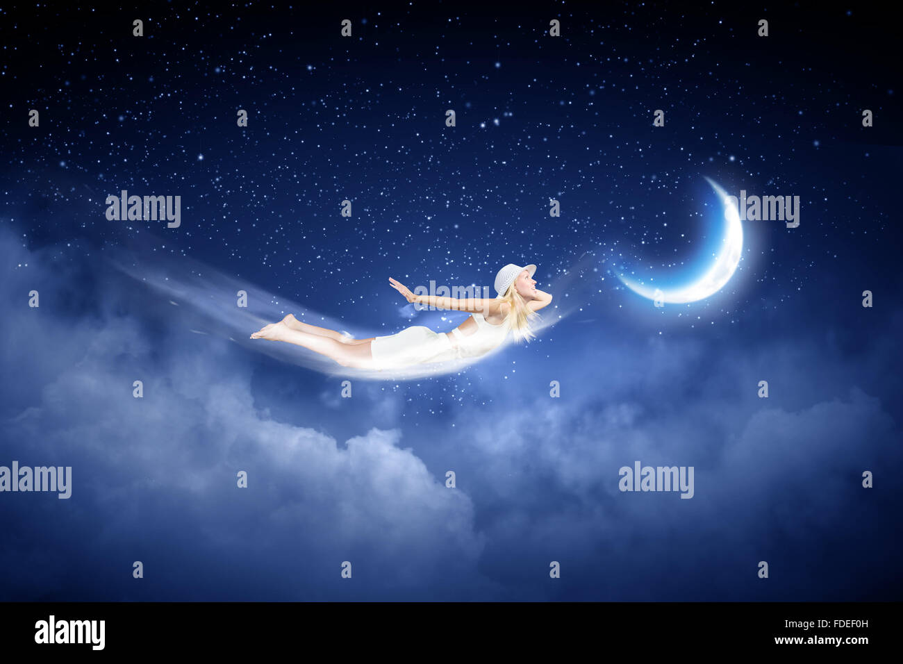Young blond girl flying in night sky Stock Photo - Alamy