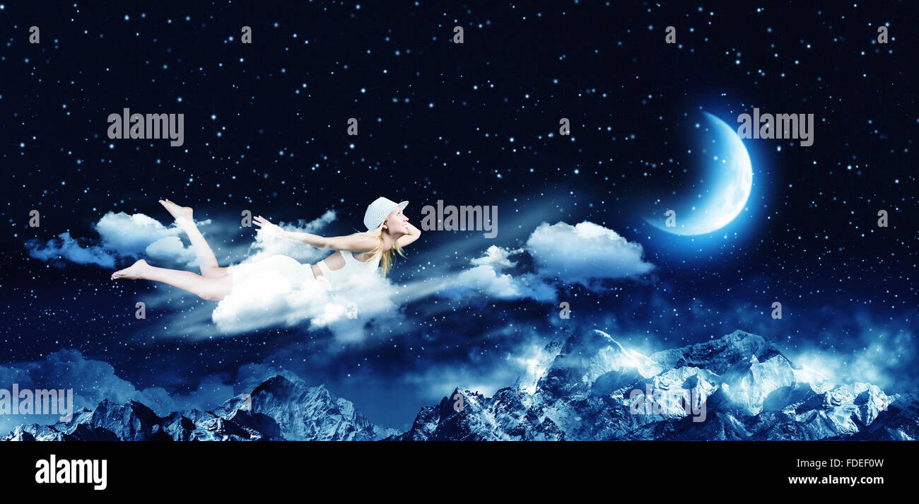 Young blond girl flying in night sky Stock Photo - Alamy