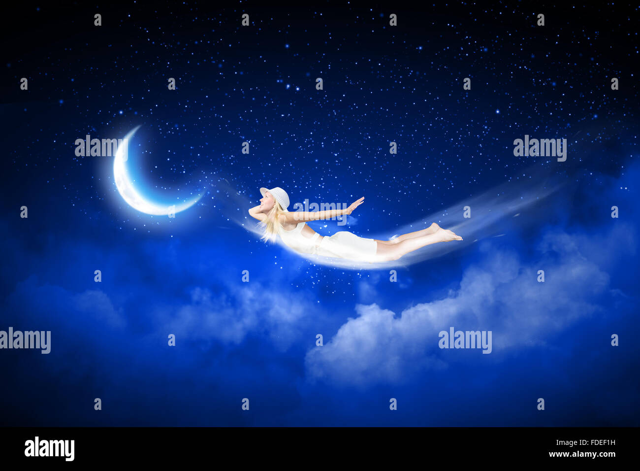 Young blond girl flying in night sky Stock Photo - Alamy