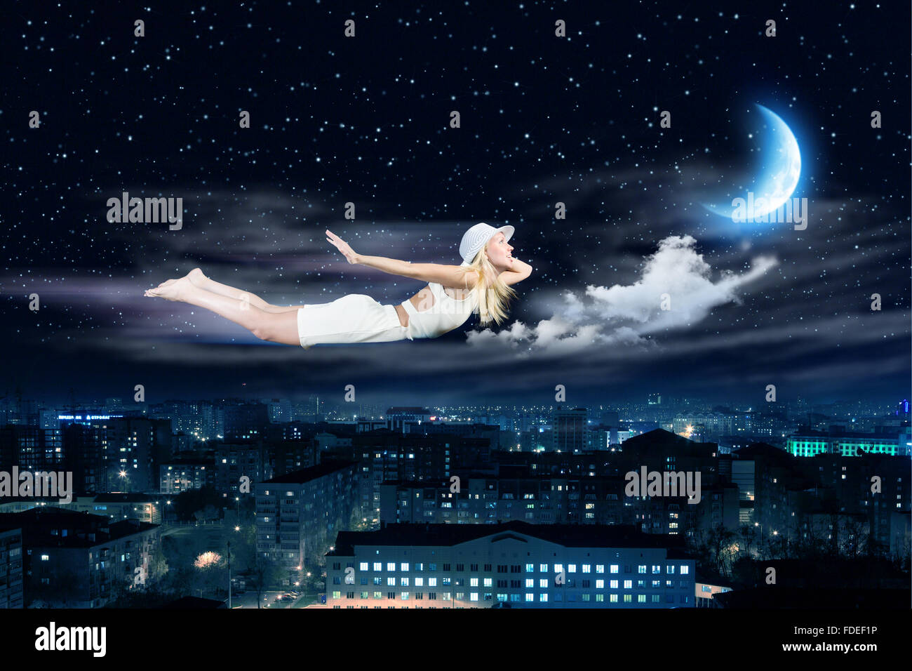 Young blond girl flying in night sky Stock Photo - Alamy
