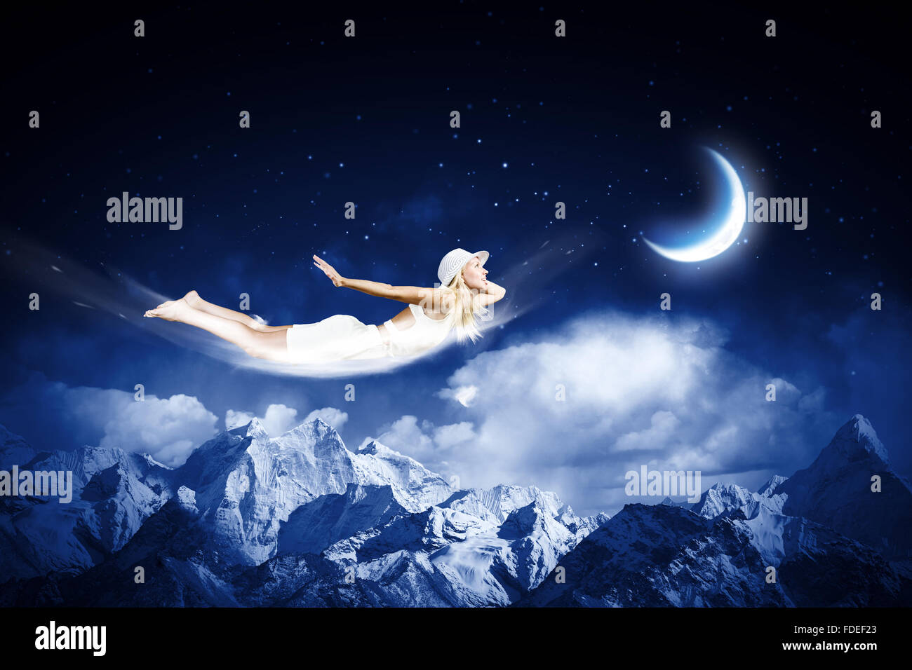 Young blond girl flying in night sky Stock Photo - Alamy