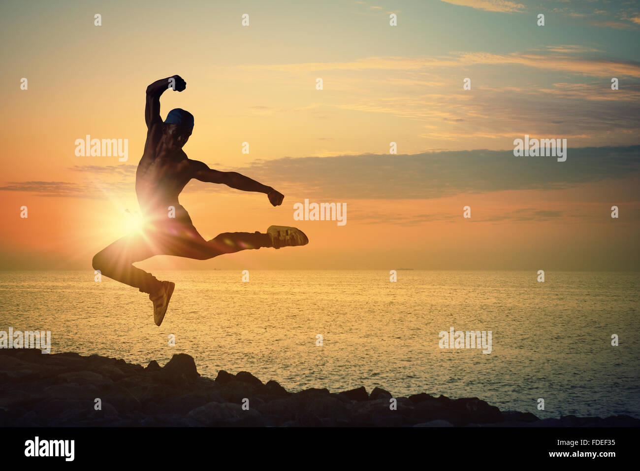 Silhouette of dancer jumping against city in lights of sunrise Stock ...