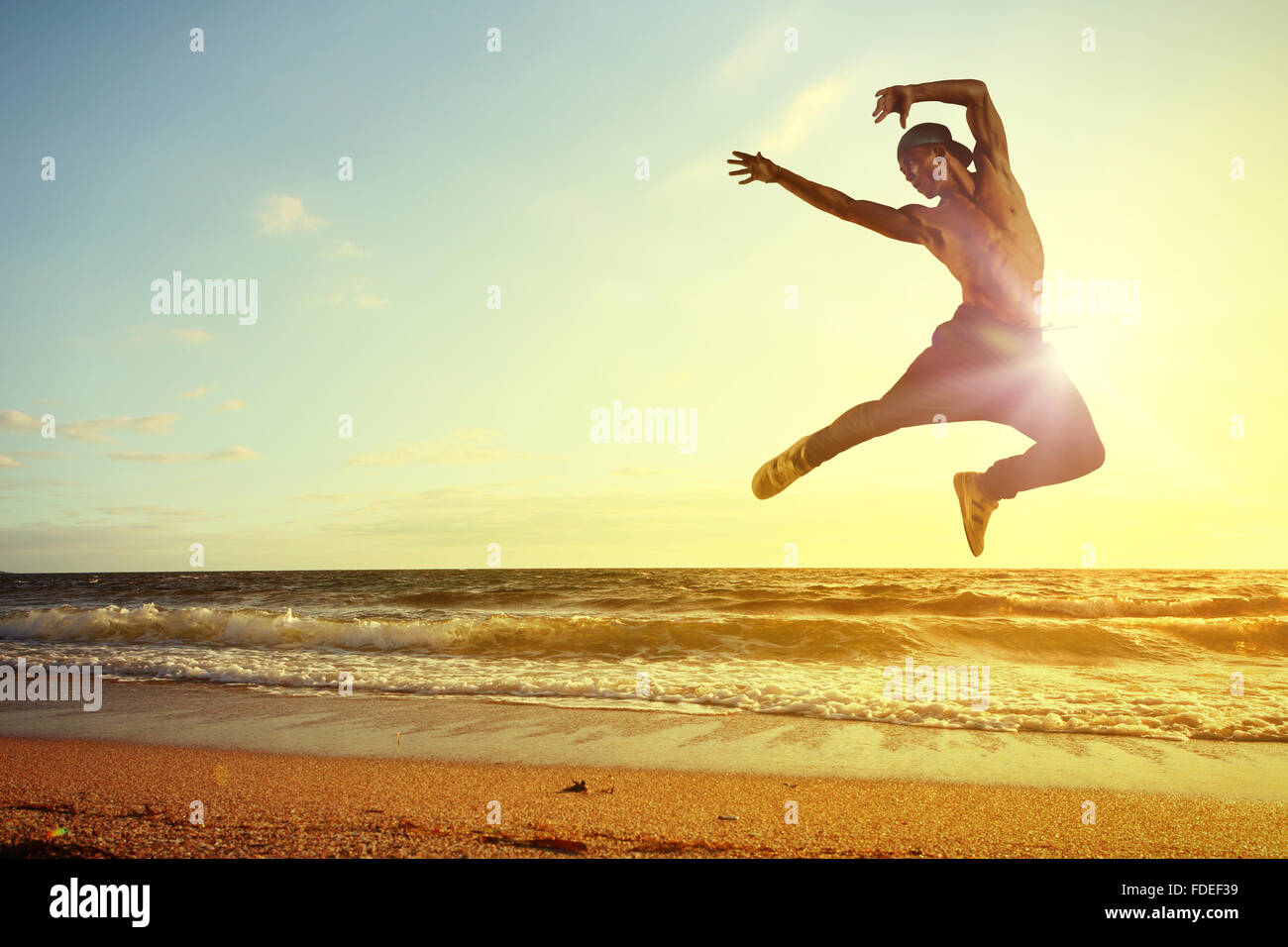 Silhouette of dancer jumping against city in lights of sunrise Stock ...