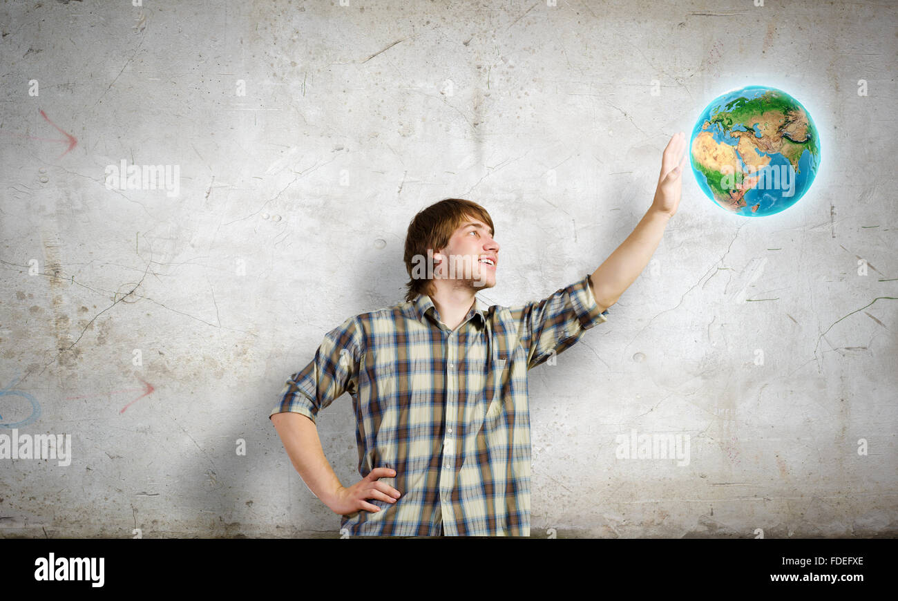 Young man touching image of Earth planet. Elements of this image are ...