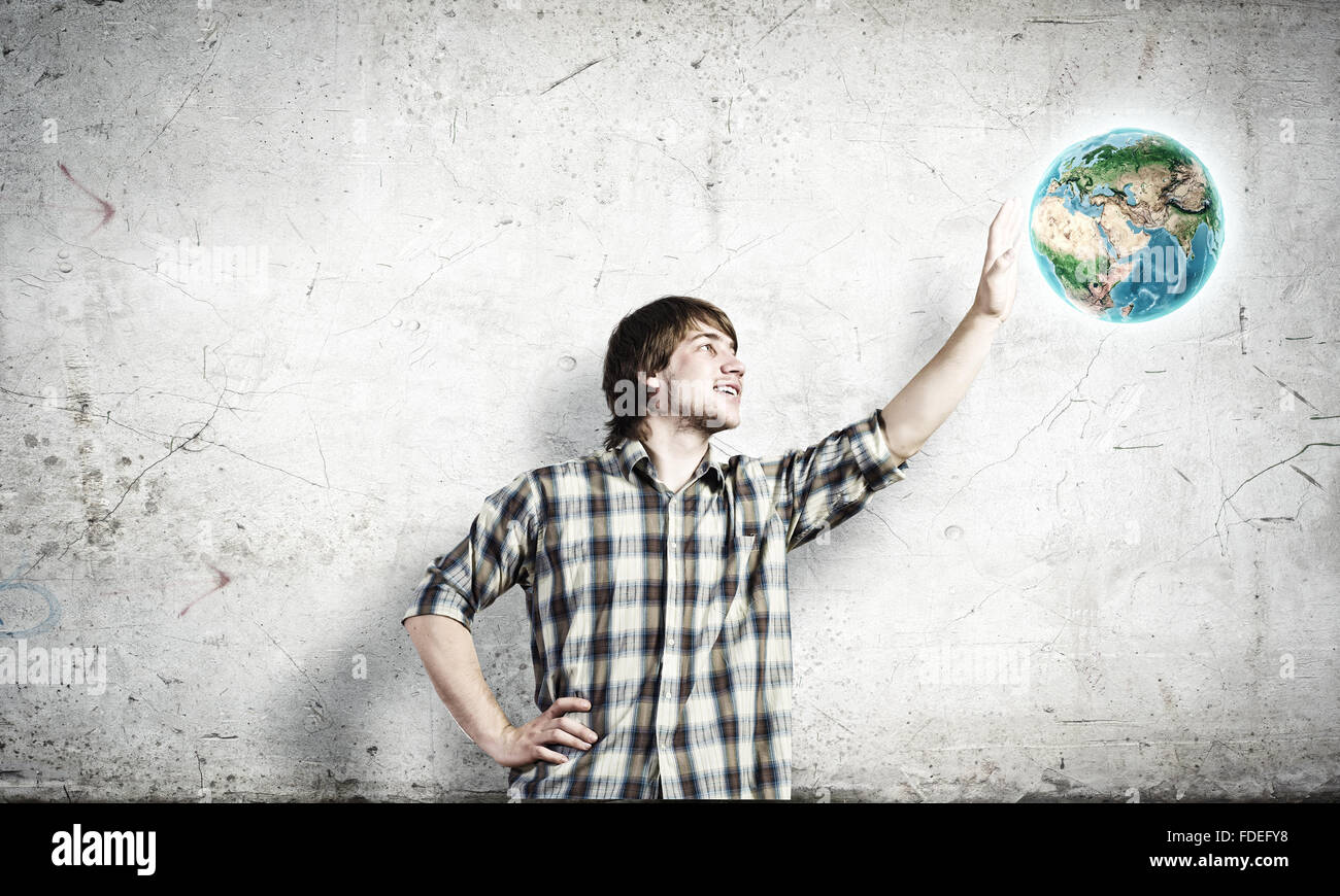 Young man touching image of Earth planet. Elements of this image are ...