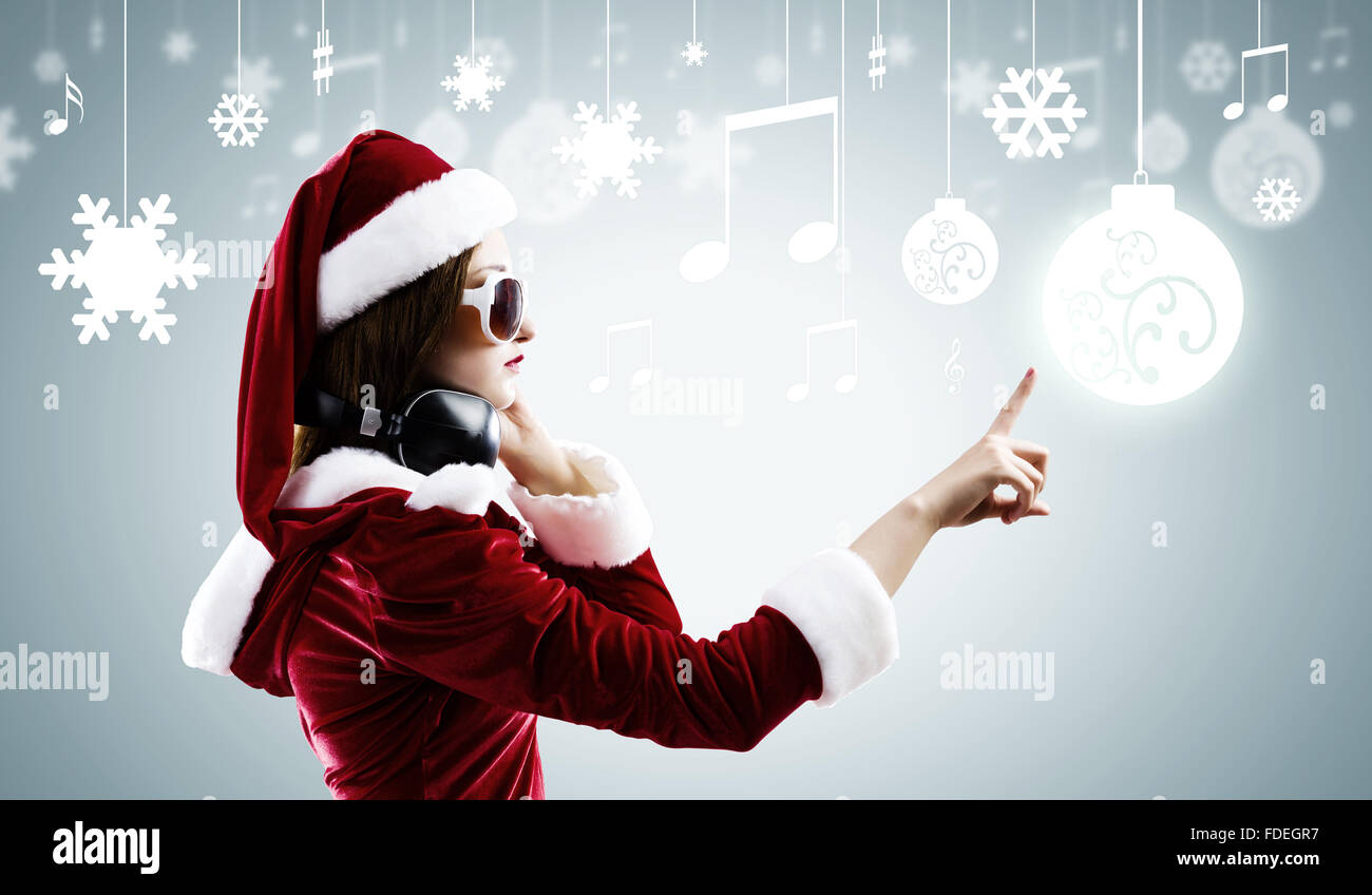Young attractive Santa girl listening music in headphones Stock Photo ...