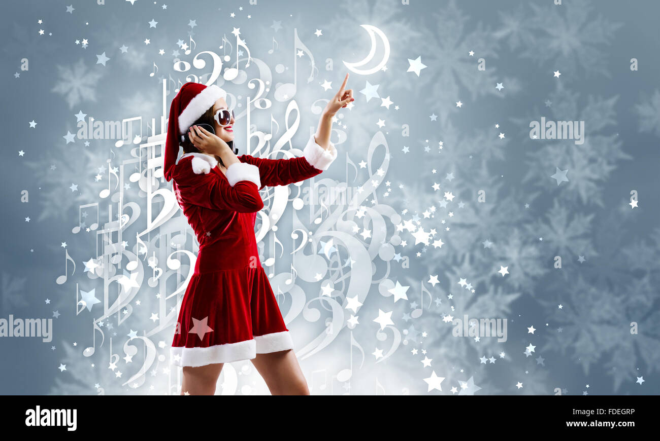 Young attractive Santa girl listening music in headphones Stock Photo ...