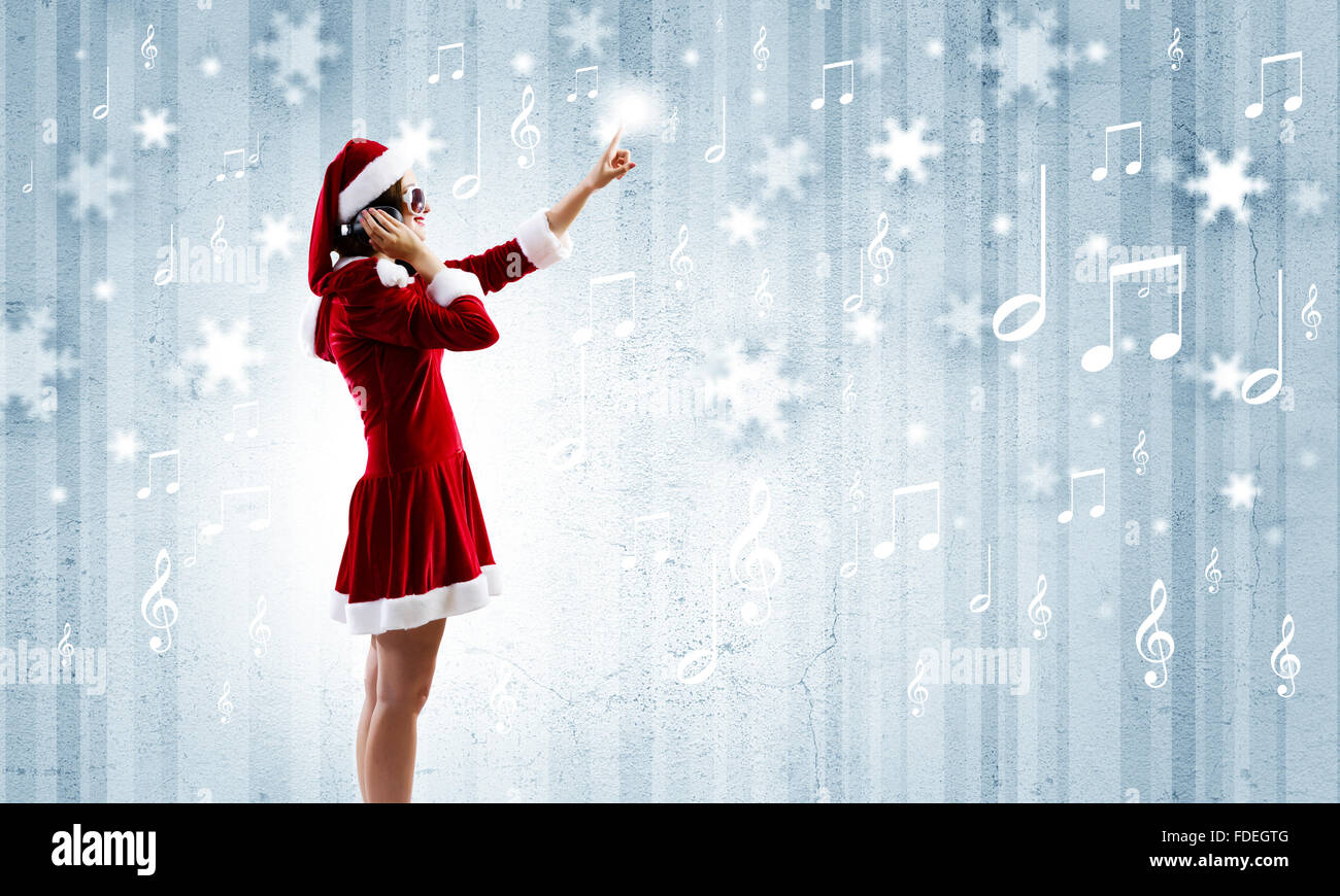 Young attractive Santa girl listening music in headphones Stock Photo ...