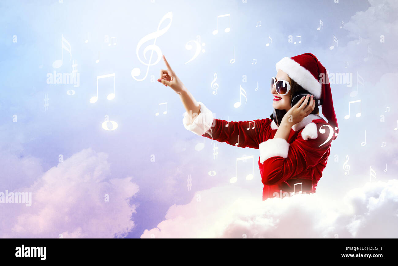 Young attractive Santa girl listening music in headphones Stock Photo ...