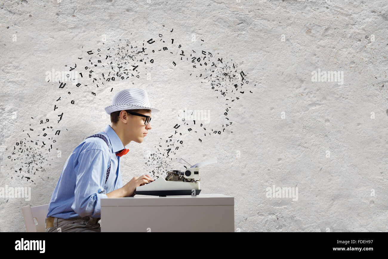 Young funny man in glasses writing on typewriter Stock Photo - Alamy
