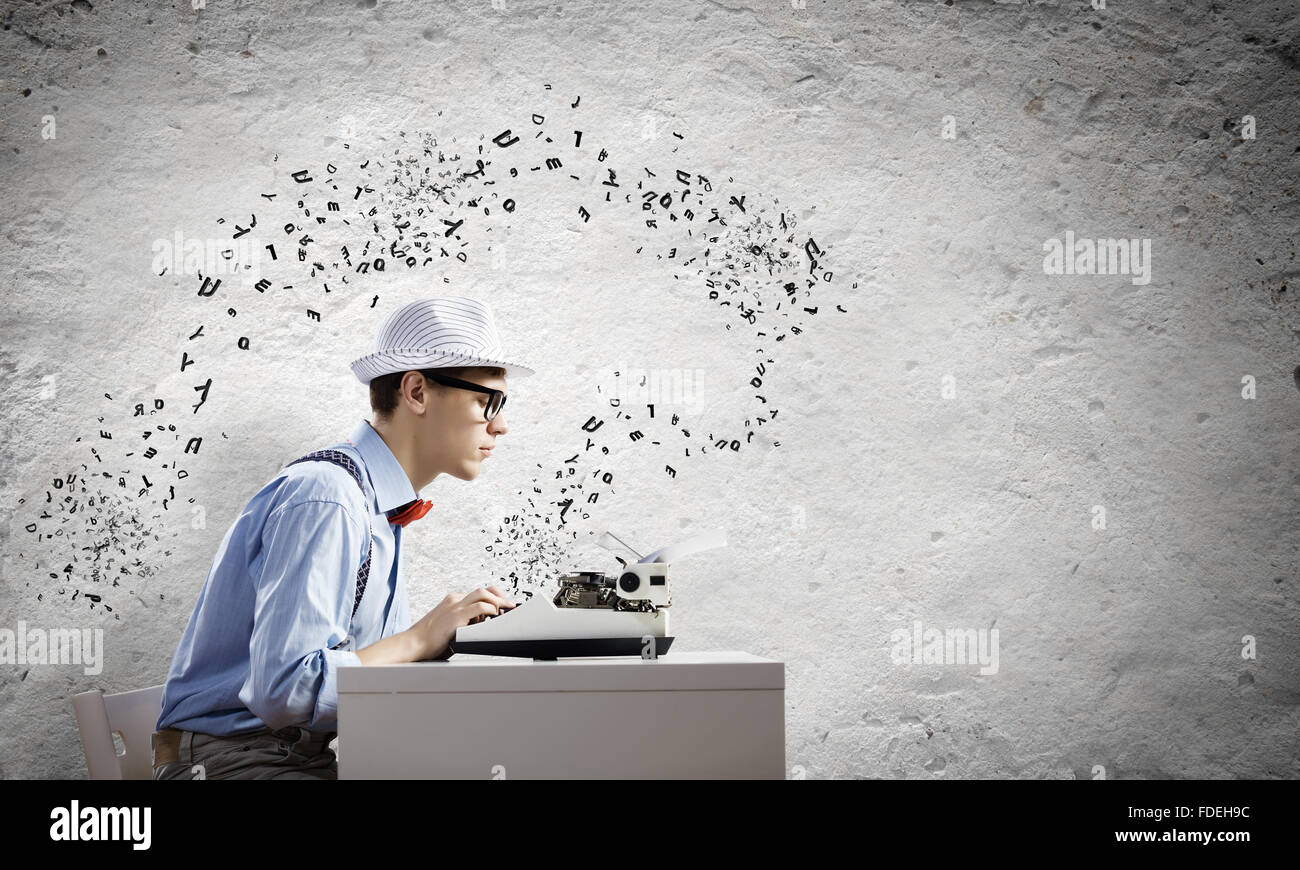 Young funny man in glasses writing on typewriter Stock Photo - Alamy