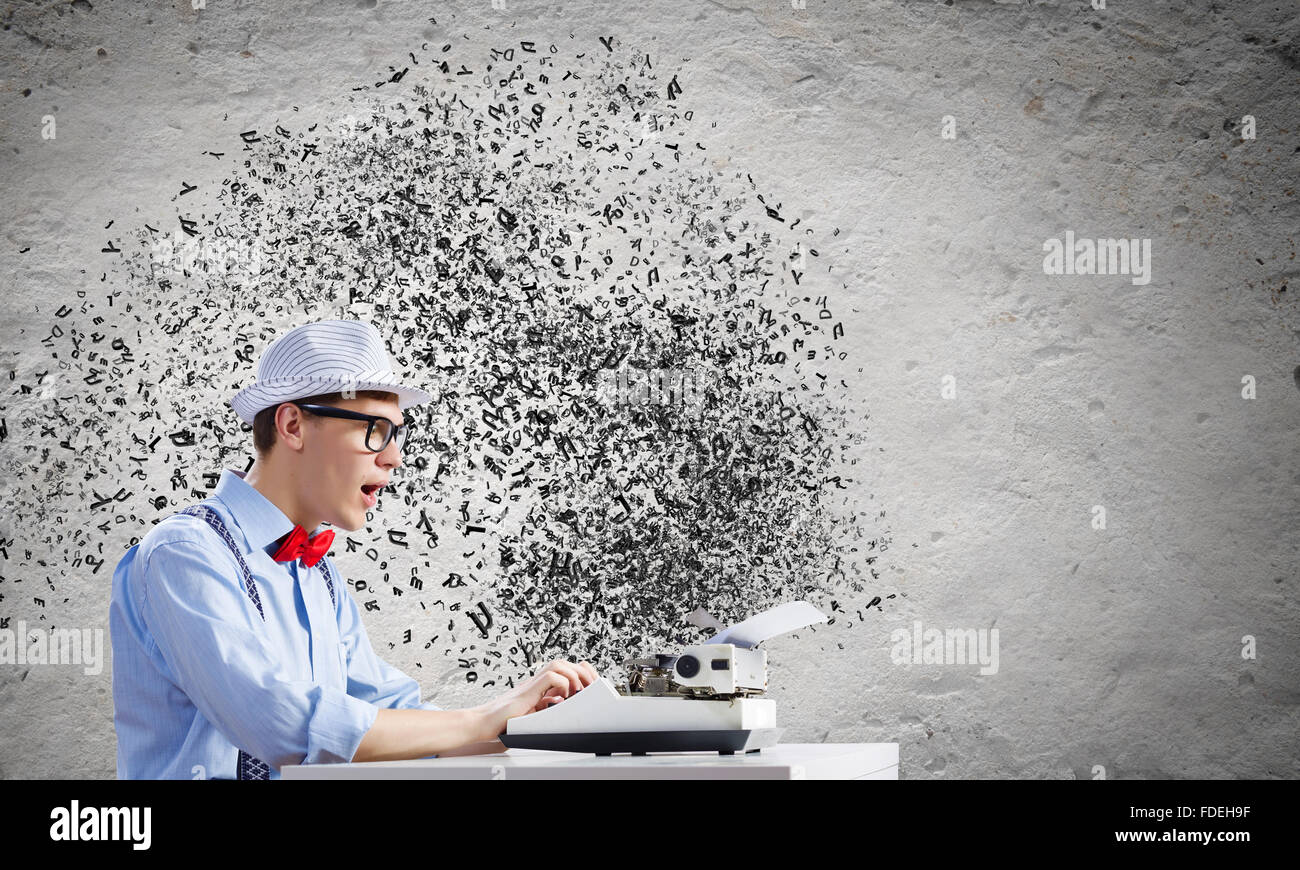 Young funny man in glasses writing on typewriter Stock Photo - Alamy