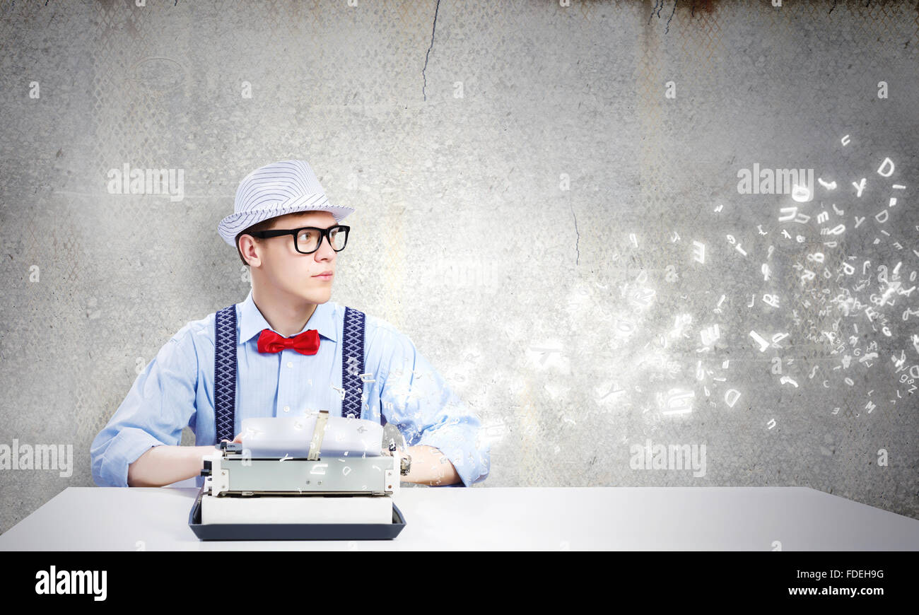 Young funny man in glasses writing on typewriter Stock Photo - Alamy