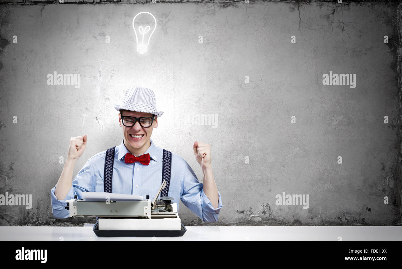 Young funny man in glasses writing on typewriter Stock Photo - Alamy