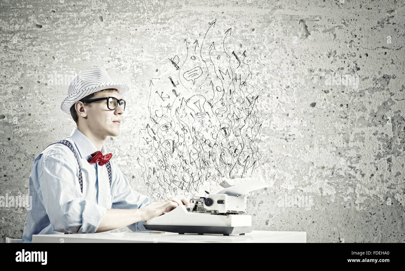 Young funny man in glasses writing on typewriter Stock Photo - Alamy
