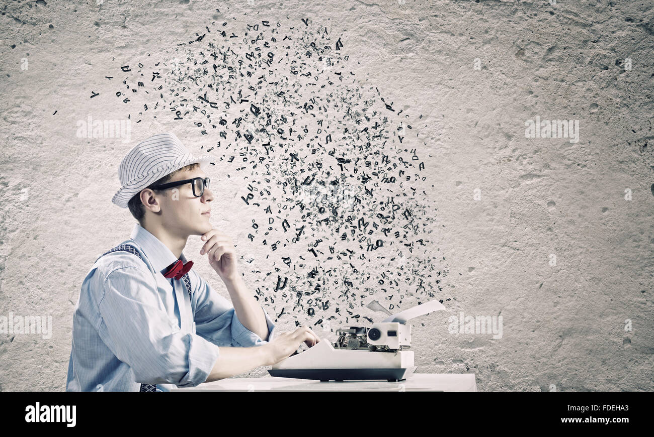 Young funny man in glasses writing on typewriter Stock Photo - Alamy